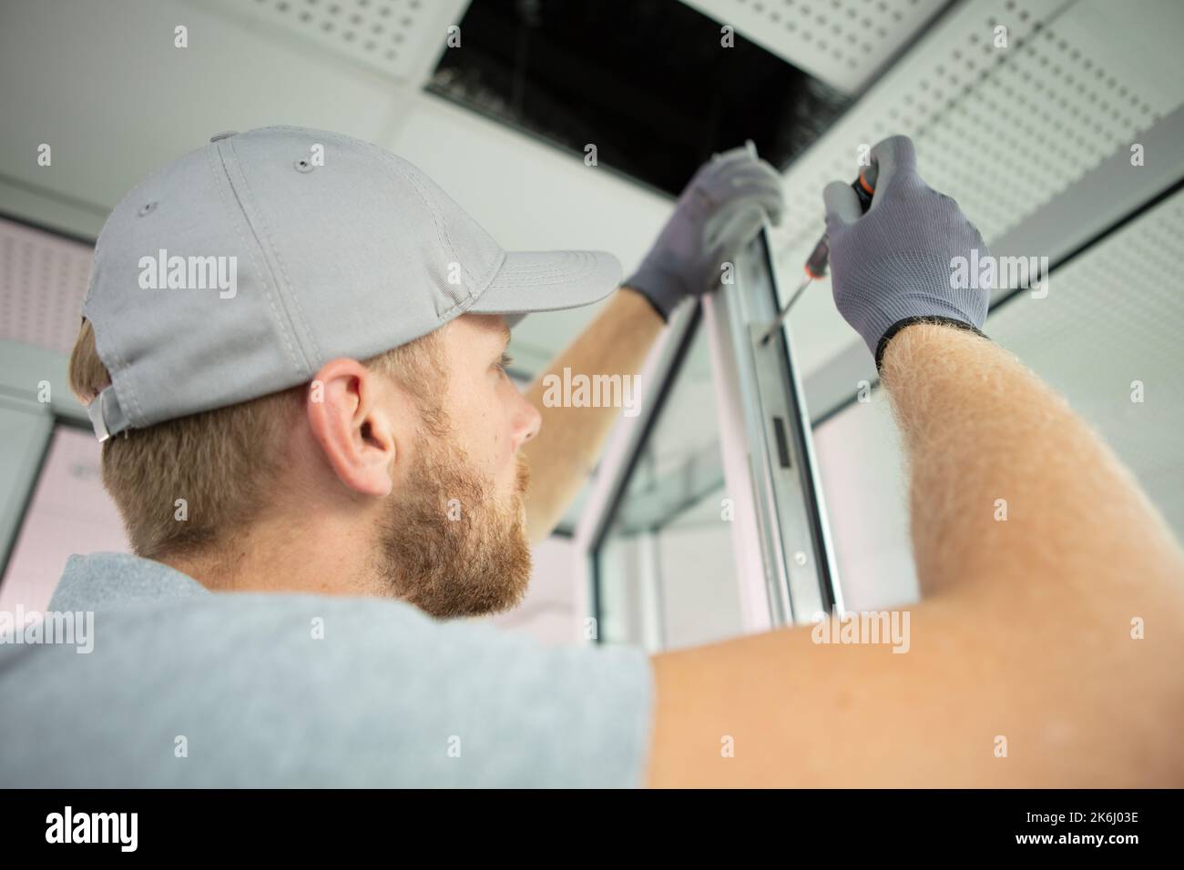 handsome young man installing bay window Stock Photo - Alamy