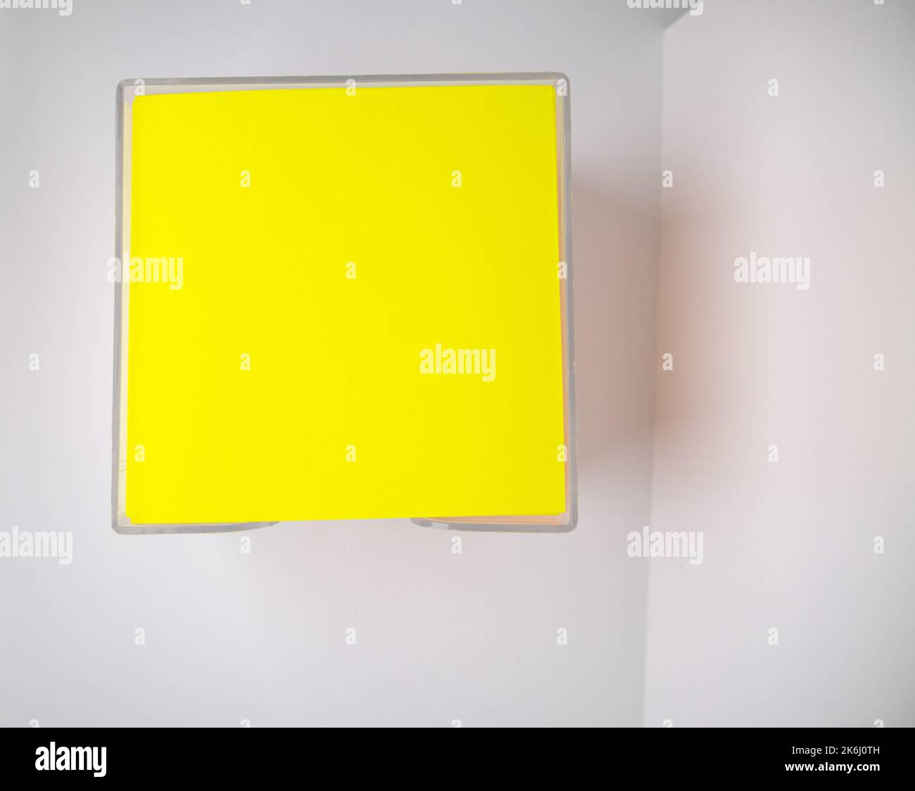 A stack of clean yellow sheets of paper on a white background, top view ...