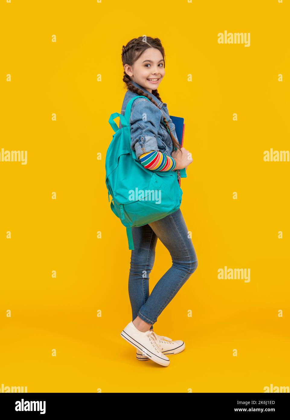 Happy schoolgirl yellow background, education. Teenage girl carrying ...
