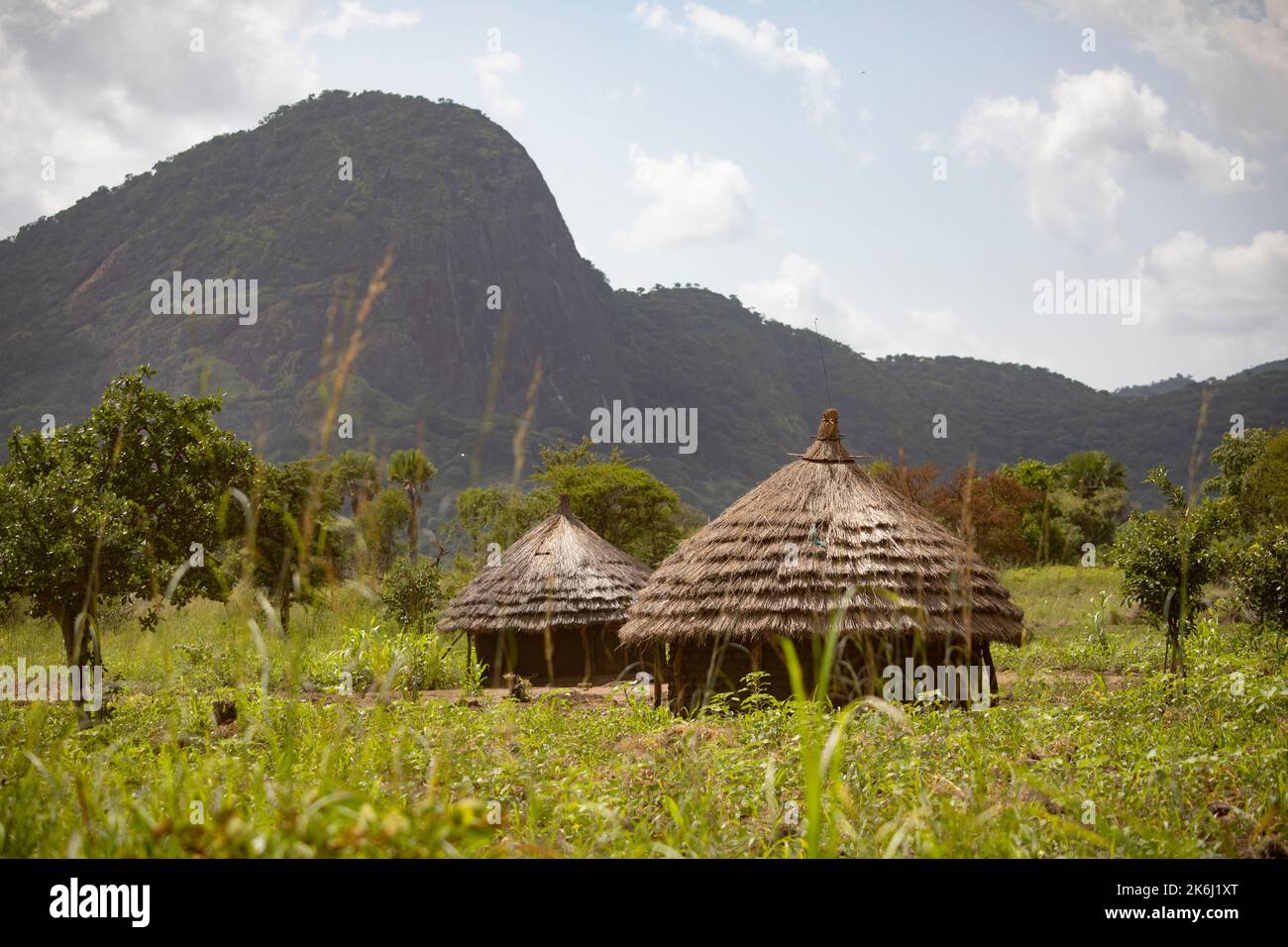 Beautiful grass thatch mud houses lay in a valley below the hills and ...