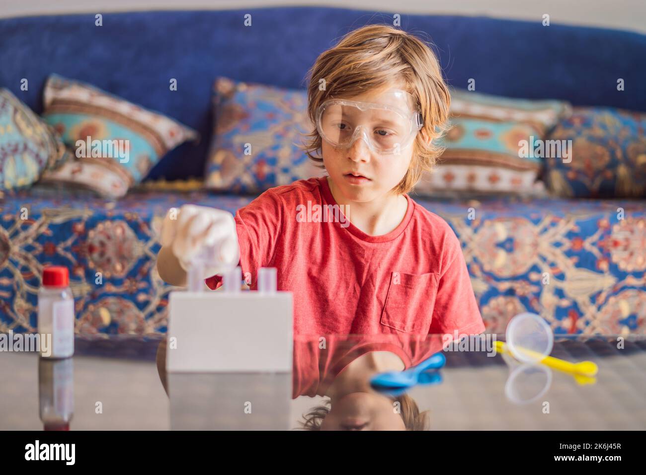 Kid boy doing chemical experiment at home. Child with protective ...