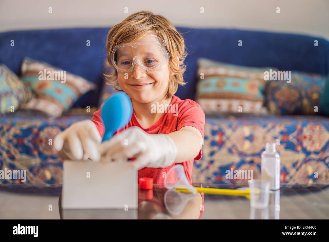 Kid boy doing chemical experiment at home. Child with protective ...