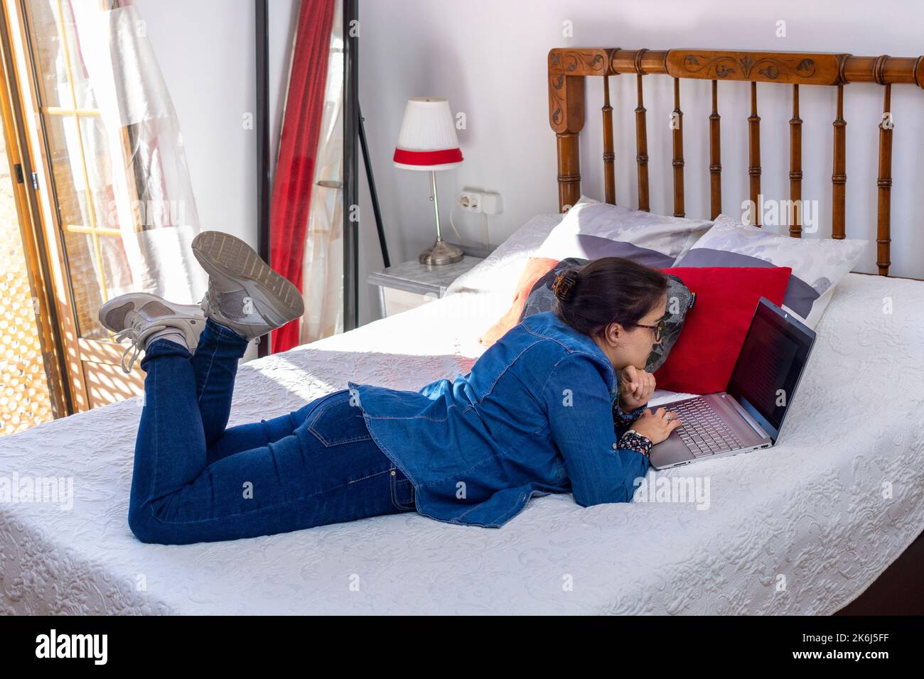 Young Woman Sitting On Bed Making Video Call With Laptop Stock Photo ...