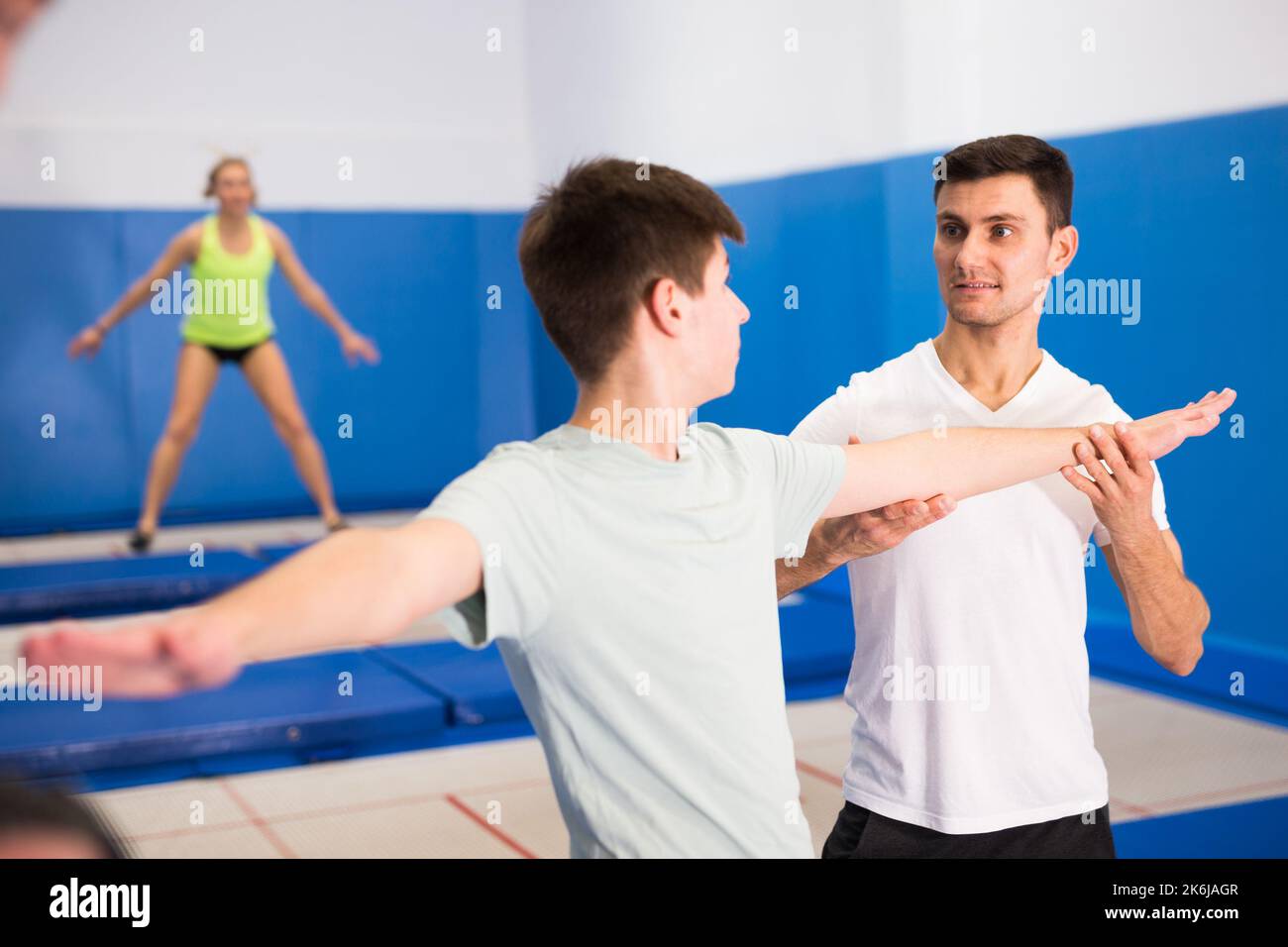 Coach holding training with teenager in trampoline room Stock Photo - Alamy