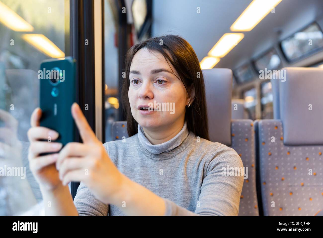 Woman taking pictures with her smartphone during train ride Stock Photo ...