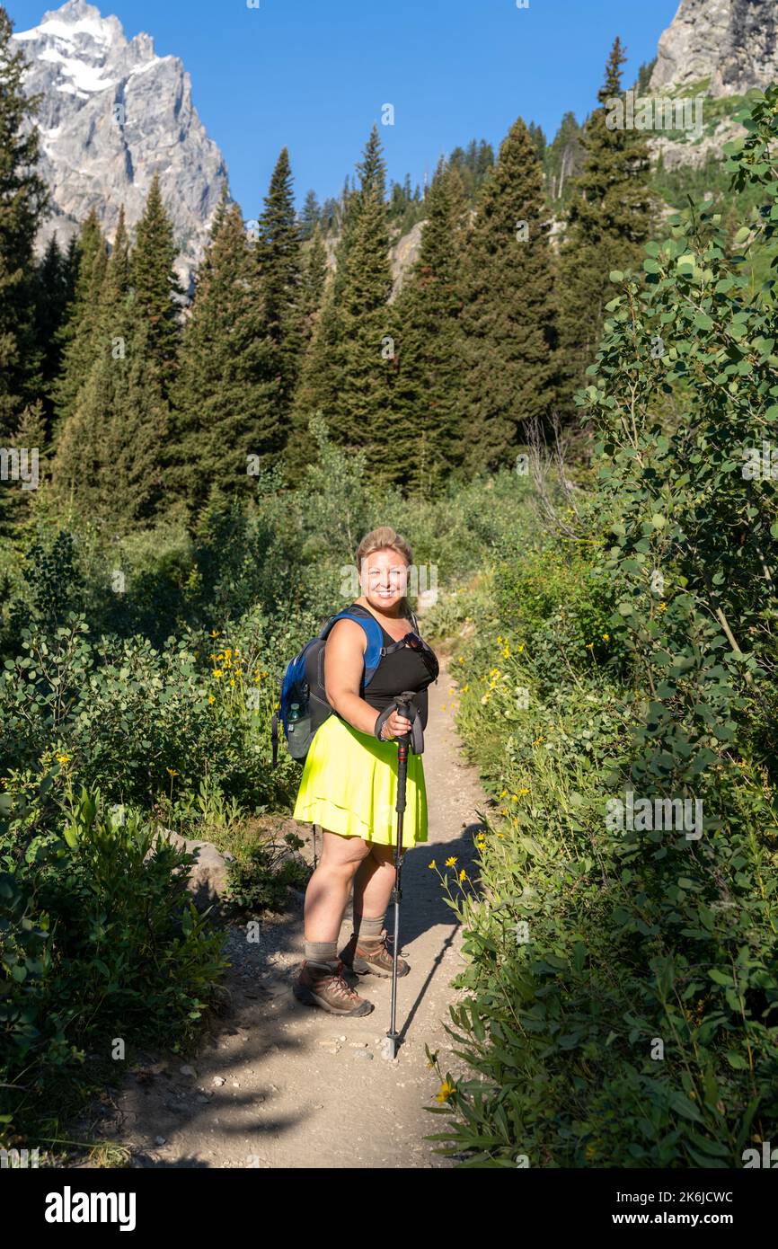 Cute, confident blonde woman poses while on the Cascade Canyon trail in ...