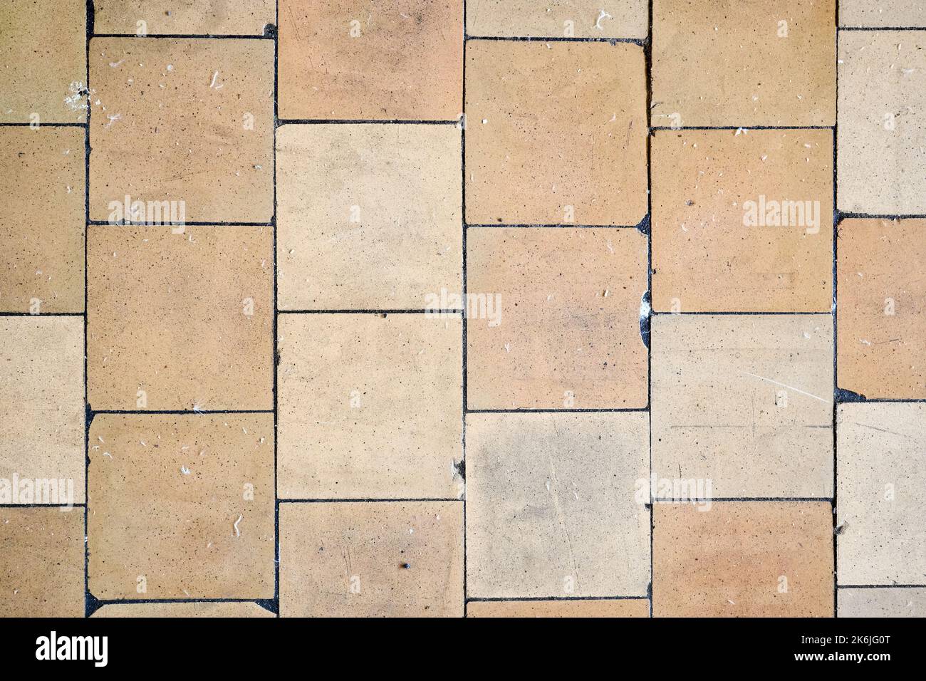 Orange brown purple old shabby worn out floor tiles with damages cracks ...