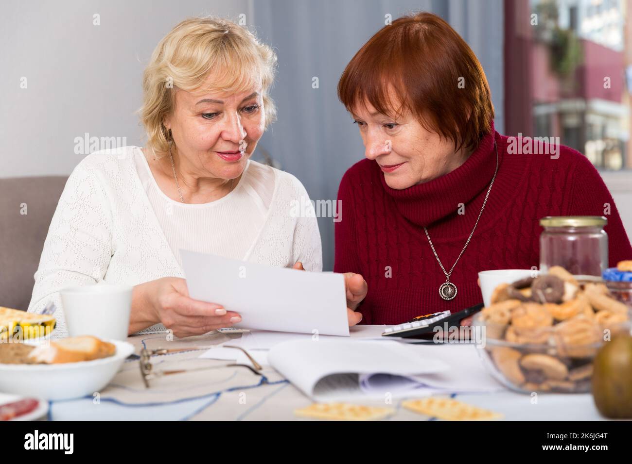 Two positive mature women with papers Stock Photo - Alamy