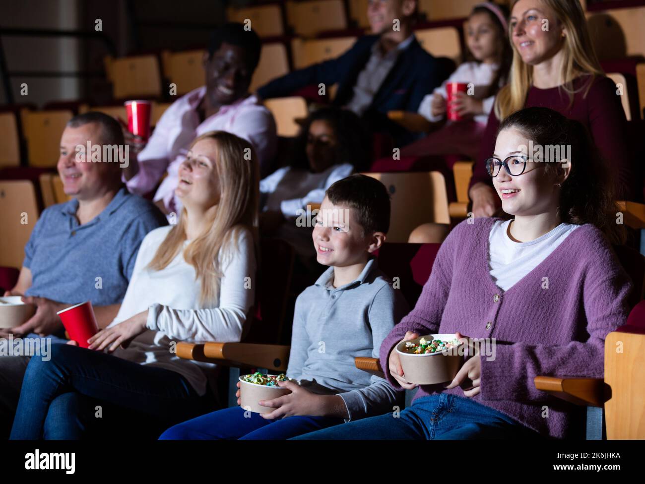Spectators eating popcorn and watching a movie at cinema Stock Photo ...