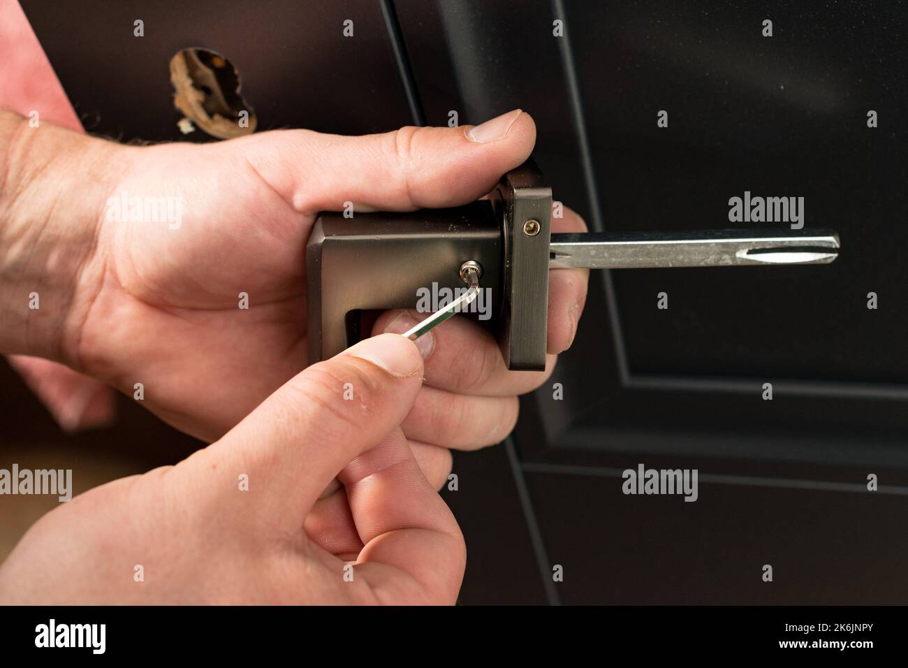 Handyman holding a doorknob and hex key, doorknob installation, metal ...