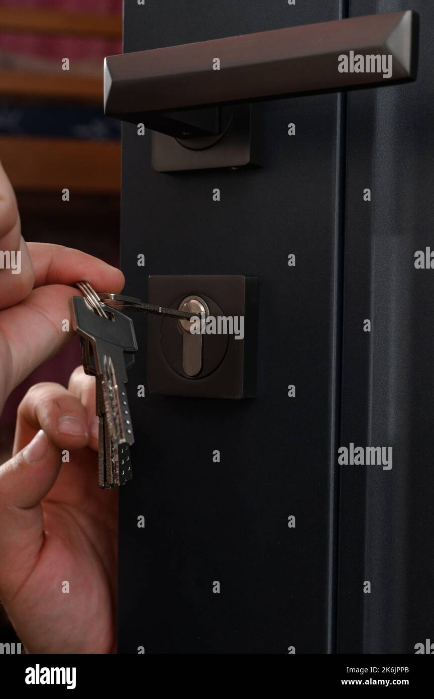 Installation of a door lock, a carpenter installs a door lock in a door ...