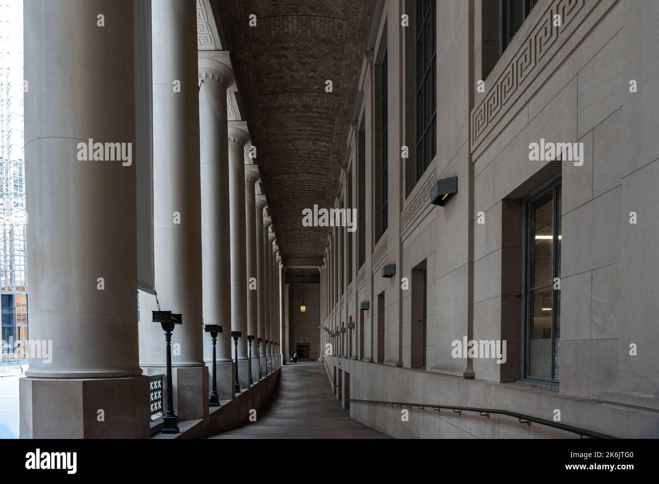 Diminishing perspective of exterior dark hallway with columns on one ...