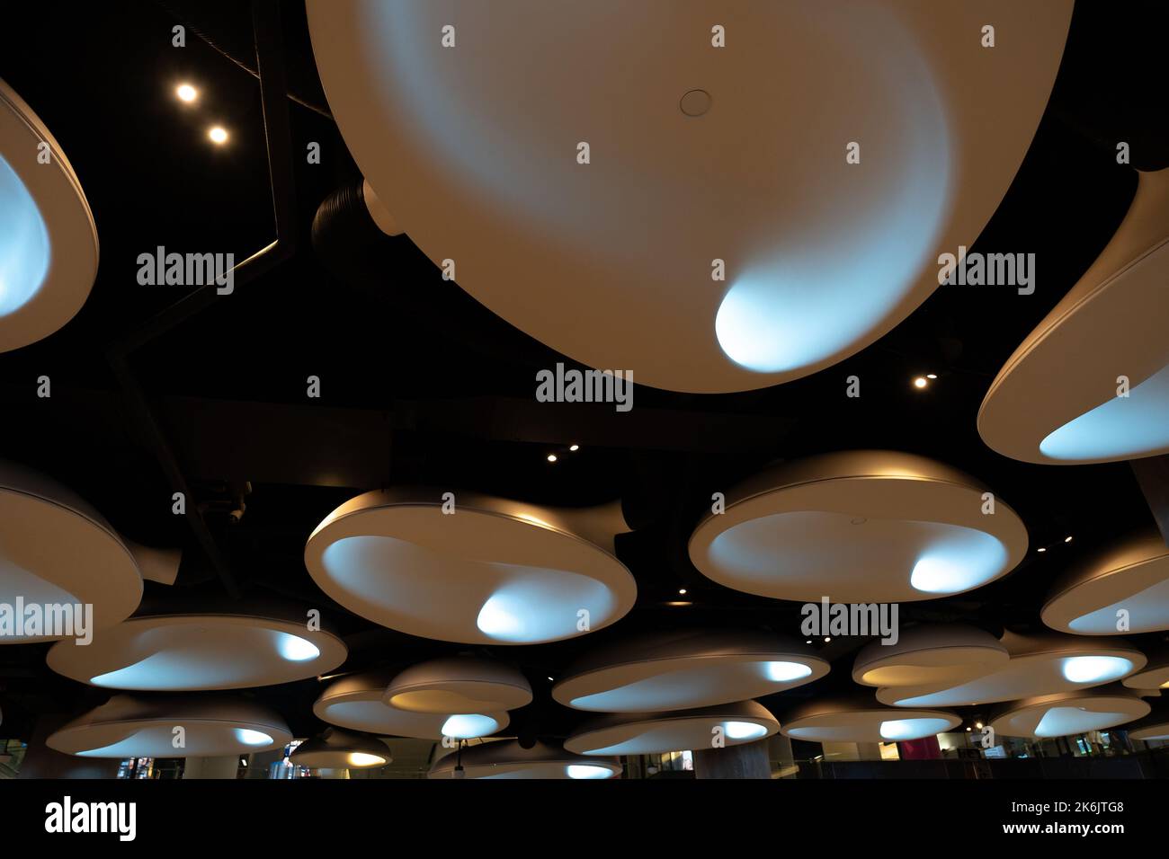 Round lamp shades attached to ceiling with soft light in a cafe Stock ...