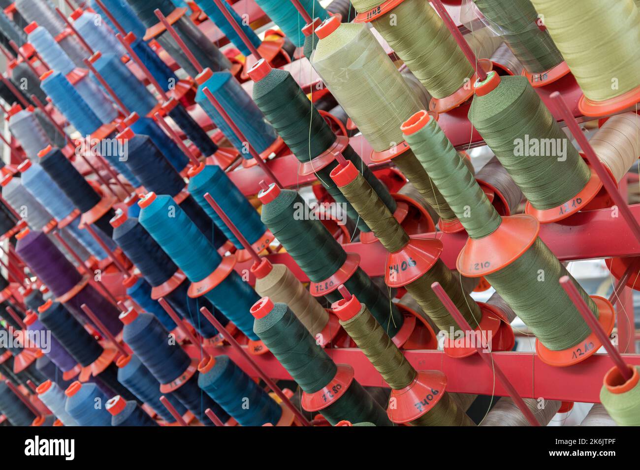Panel of colored yarn rolls for textile industry Stock Photo - Alamy