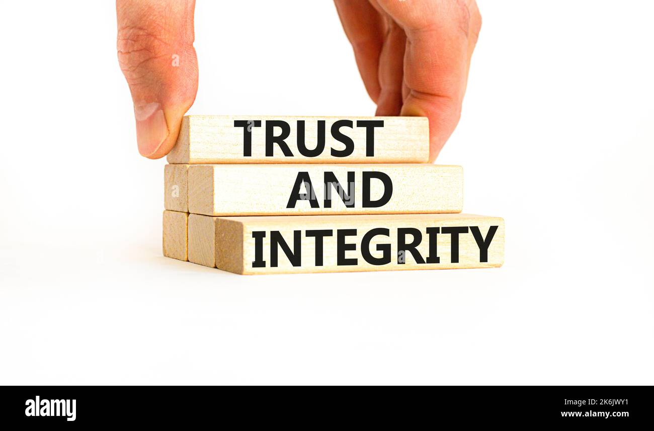 Trust and integrity symbol. Concept words Trust and integrity on wooden blocks. Businessman hand ...