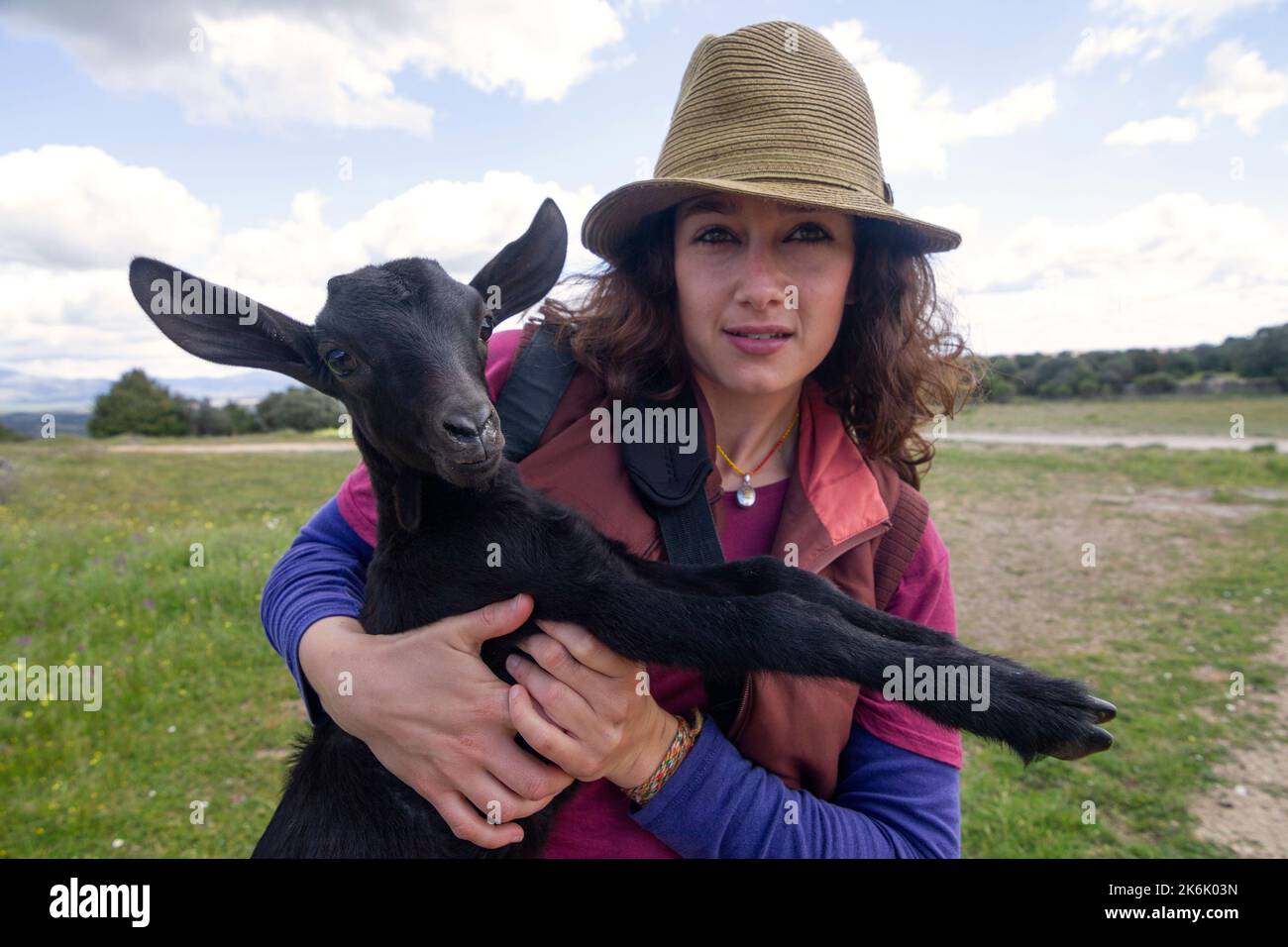 Portrait of female photographer with hat and cameras hugging a very ...