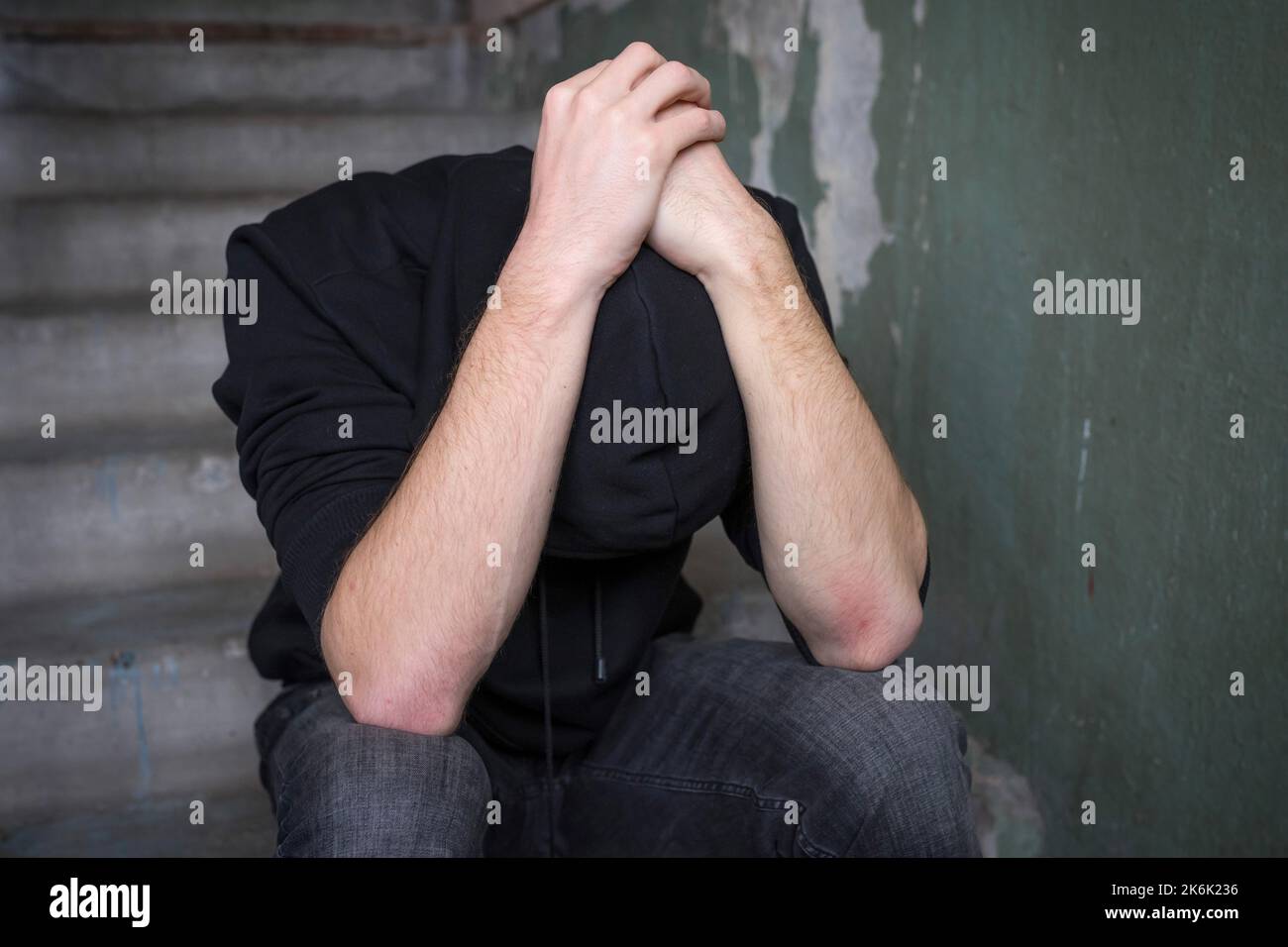 Addict in the hood of an abandoned house. The concept of drug abuse ...