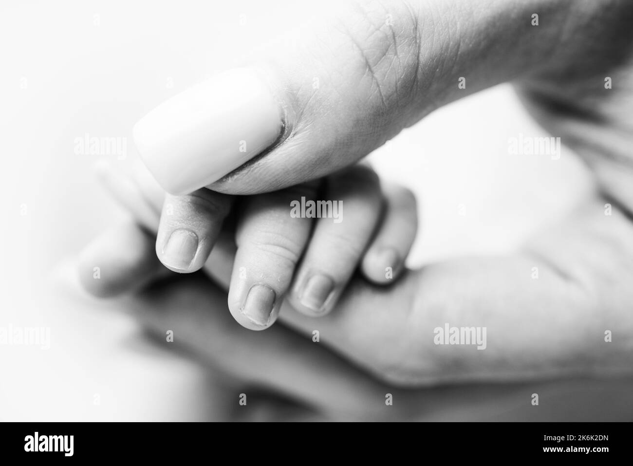 Close-up baby's small hand with tiny fingers and arm of mother. Newborn ...