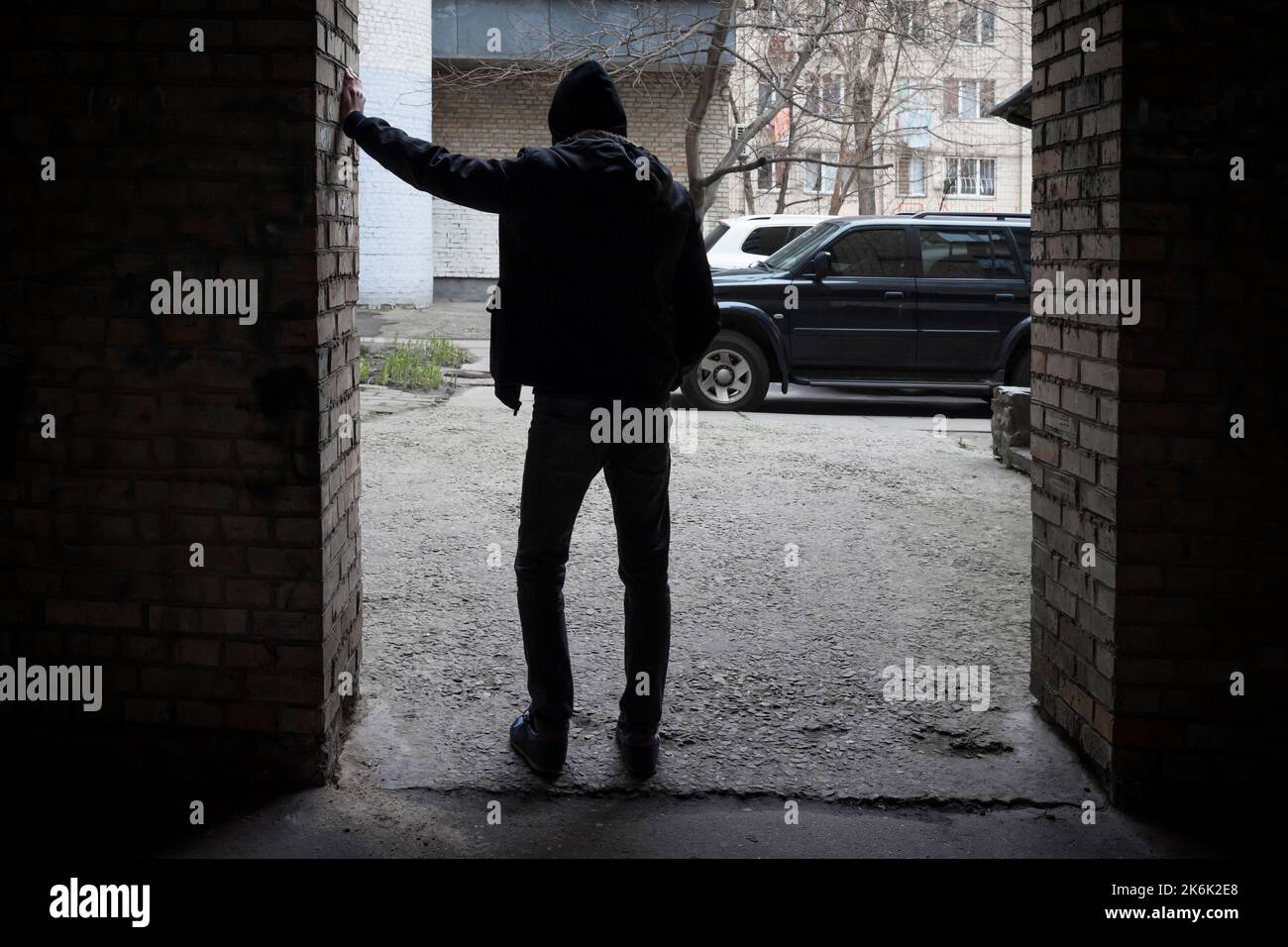A man in a sweatshirt on a city street, in a dark alley. The view from ...