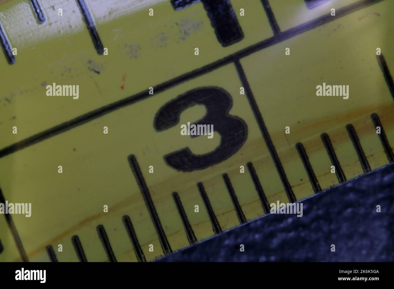 Close-up of the yellow measuring tape indicating the measure three ...