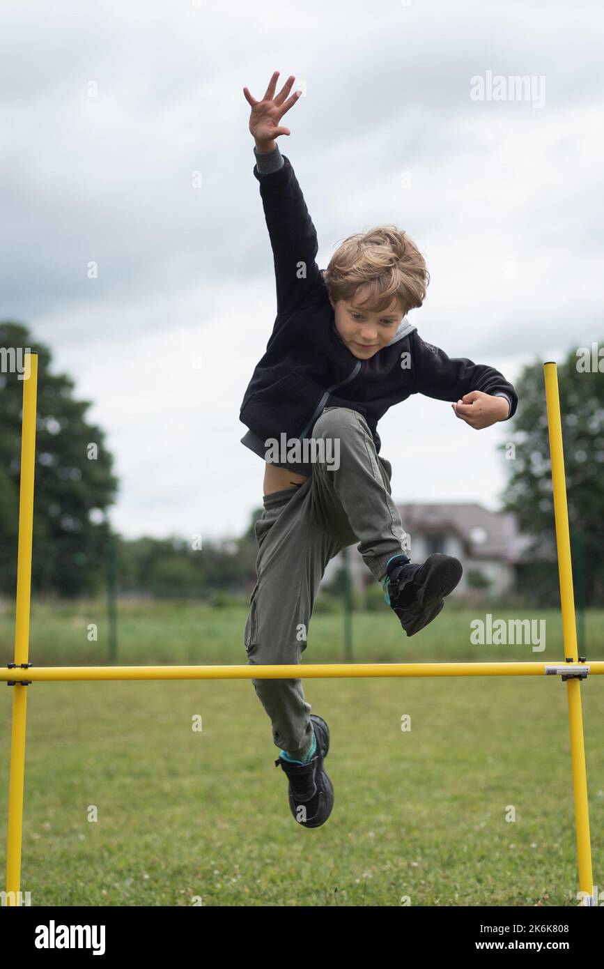 Young boy jumps up over the obstacle Stock Photo - Alamy