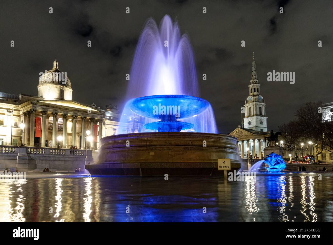Illuminated fountain at Trafalgar Square at night, London England ...