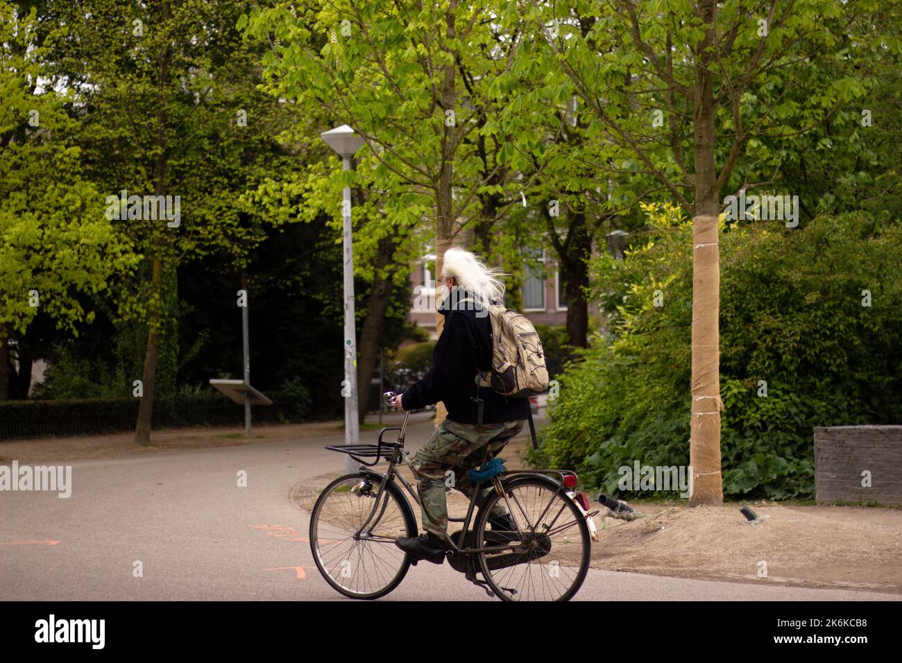 cyclist riding his bicycle through Amsterdam Stock Photo - Alamy