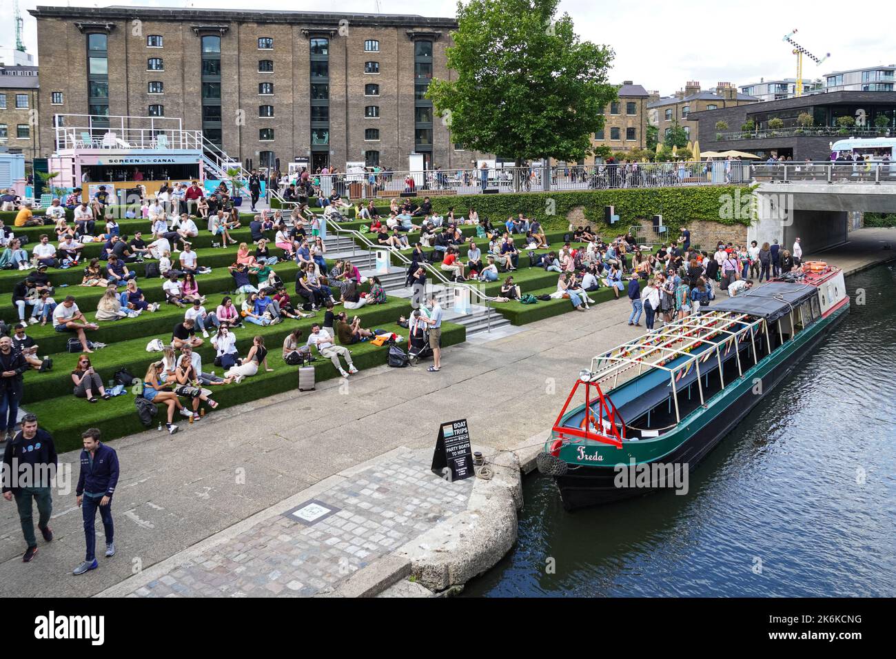 People sitting on steps at Granary Square at King's Cross, London ...