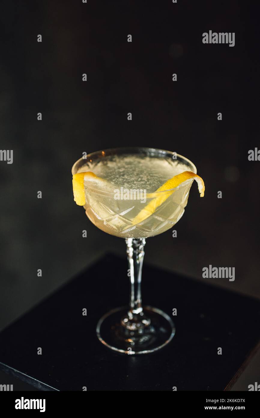 fancy yellow cocktail champagne crystal coupe lemon on pedestal against ...