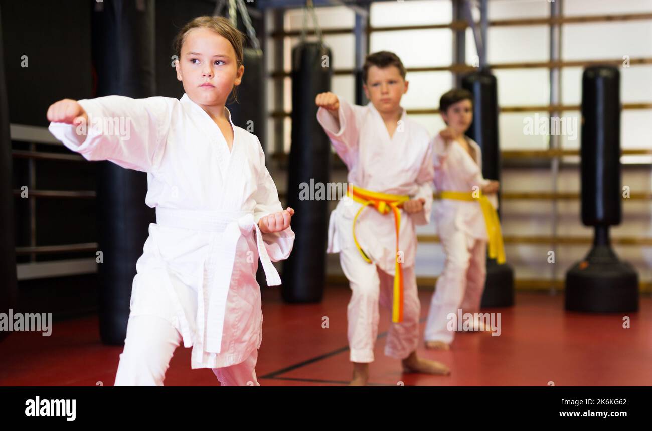 Female karate fighter in white kimono, combat stance. Children in pair ...