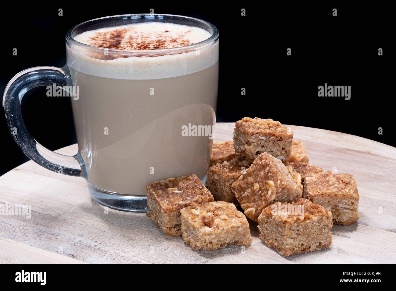 Ten oatmeal flapjacks crumbley and ready to eat along with a mug of ...