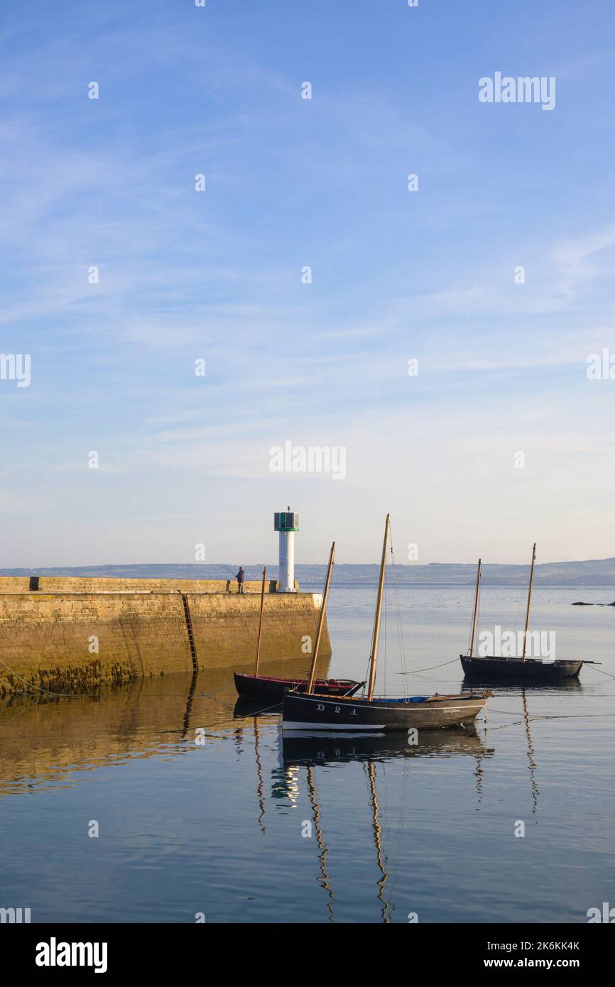Old wooden boats moored at the pier entrance to Treboul harbour ...