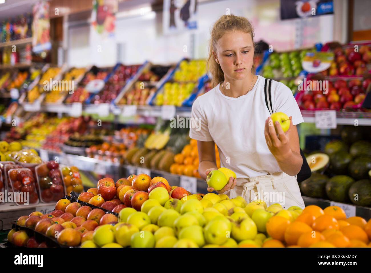 Young woman purchaser choosing apples in grocery Stock Photo - Alamy