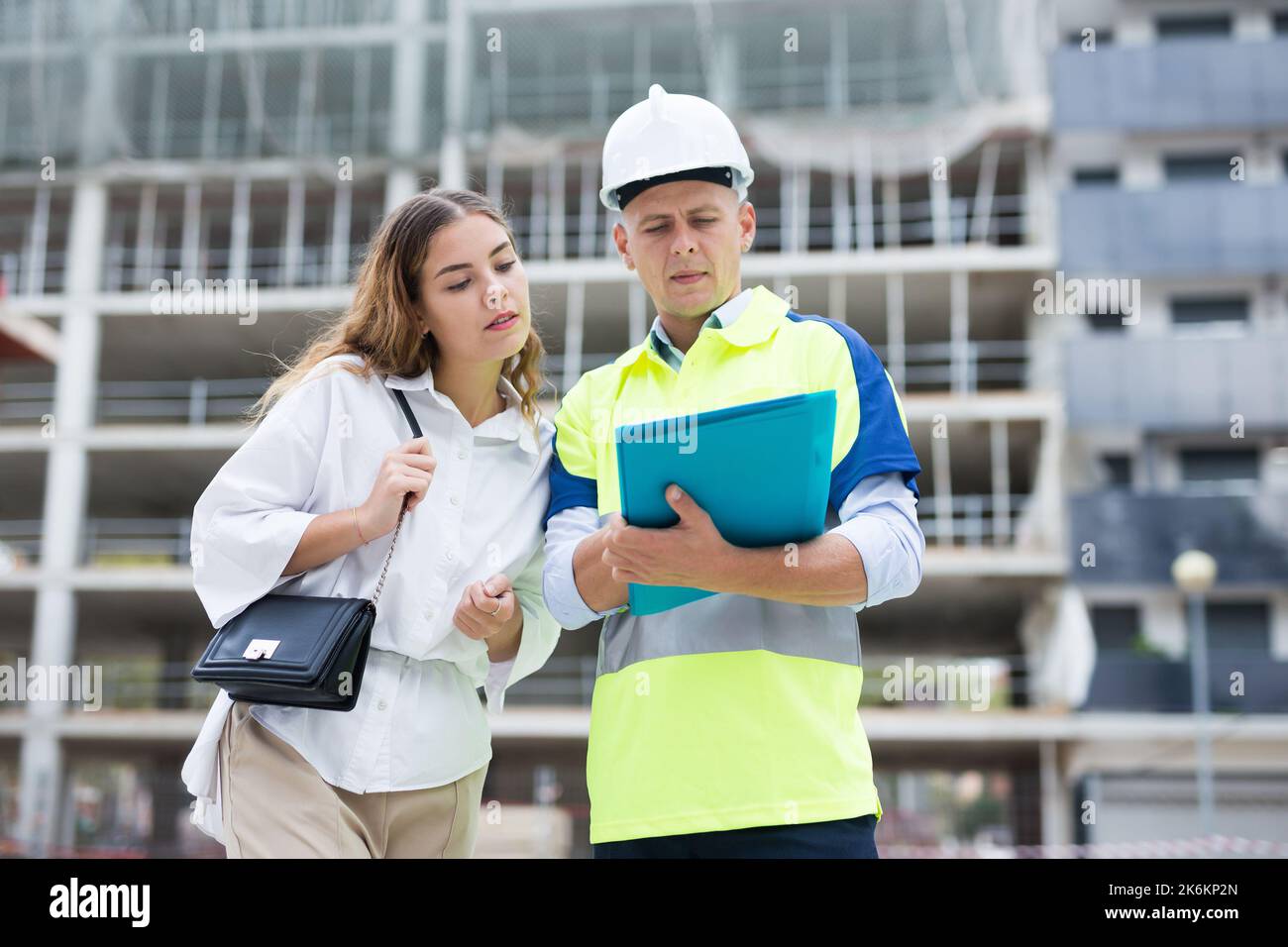 Builder talking with client at construction site Stock Photo - Alamy
