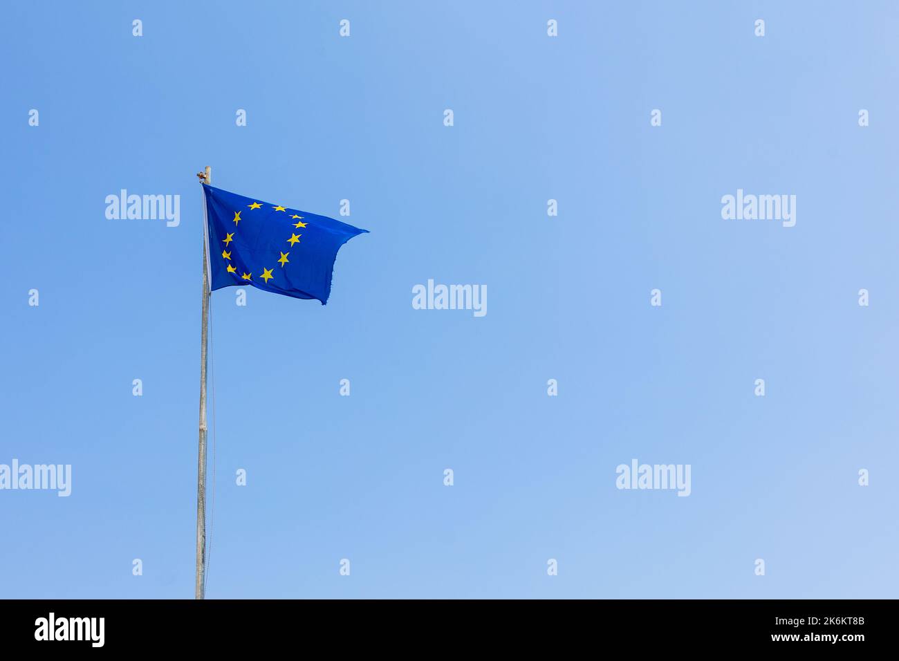 European Union EU flag is flying on blue sky background. Banner, place ...