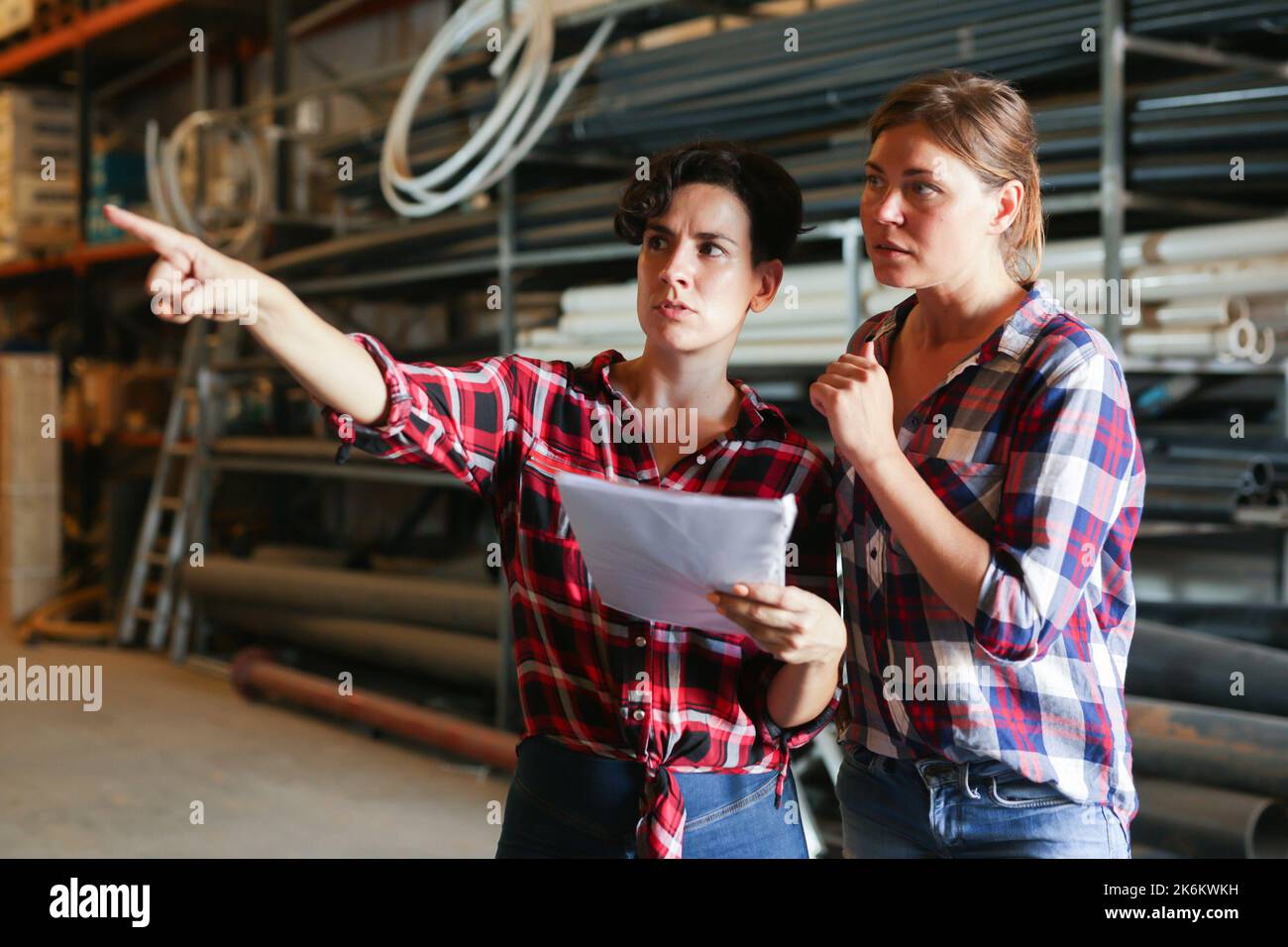 Two women verifying check list in warehouse Stock Photo - Alamy
