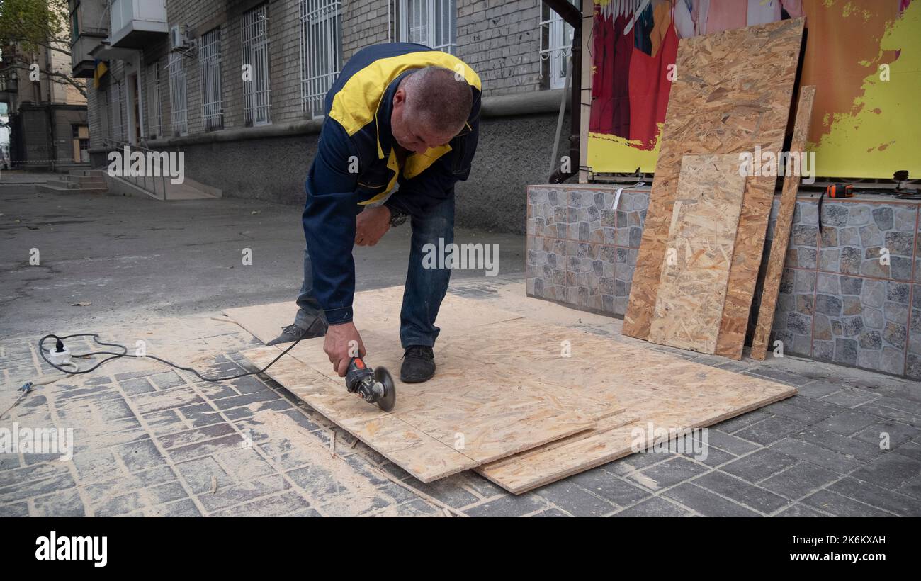 A man works on window covers at an apartment building after it was ...