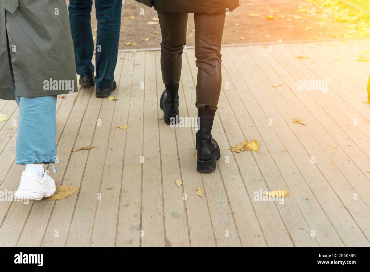 Women's legs in leather pants and boots walk among crowd of passers-by ...