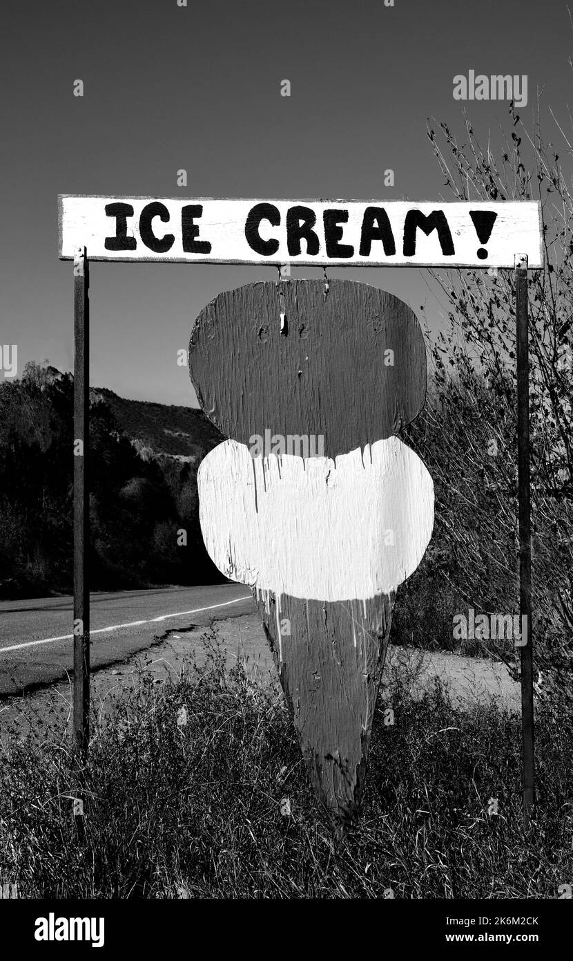 A homemade roadside sign advertises ice cream for sale beside a rural ...