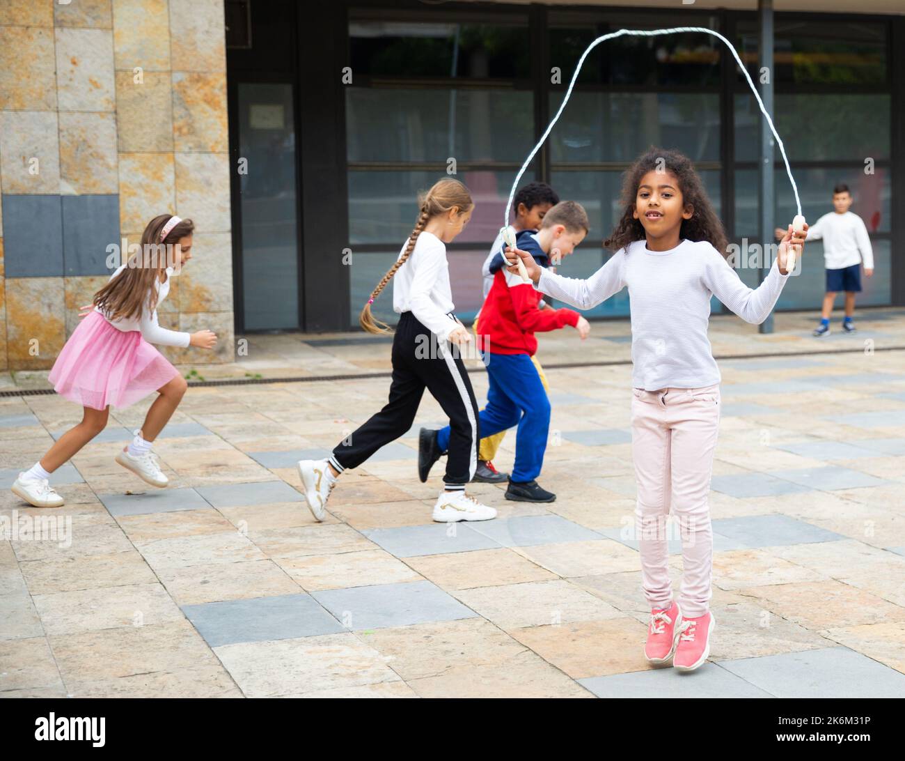 Tween African American girl skipping rope in schoolyard Stock Photo - Alamy