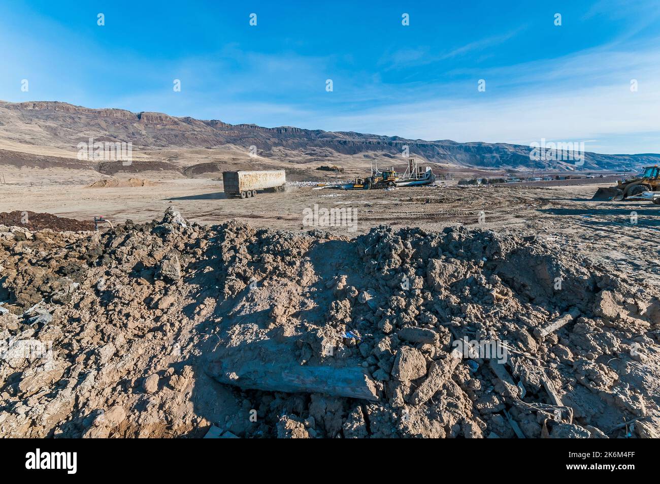 Landfill showing clay soil and a tractor-trailer approaching a trailer ...