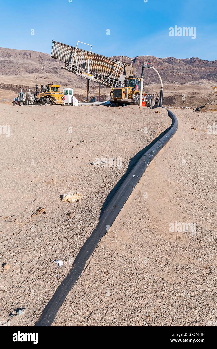 A vertical landfill methane gas well at an active landfill showing a ...