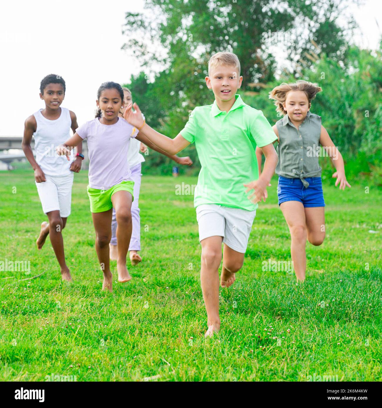 Five smiling kids running and laughing in park Stock Photo - Alamy