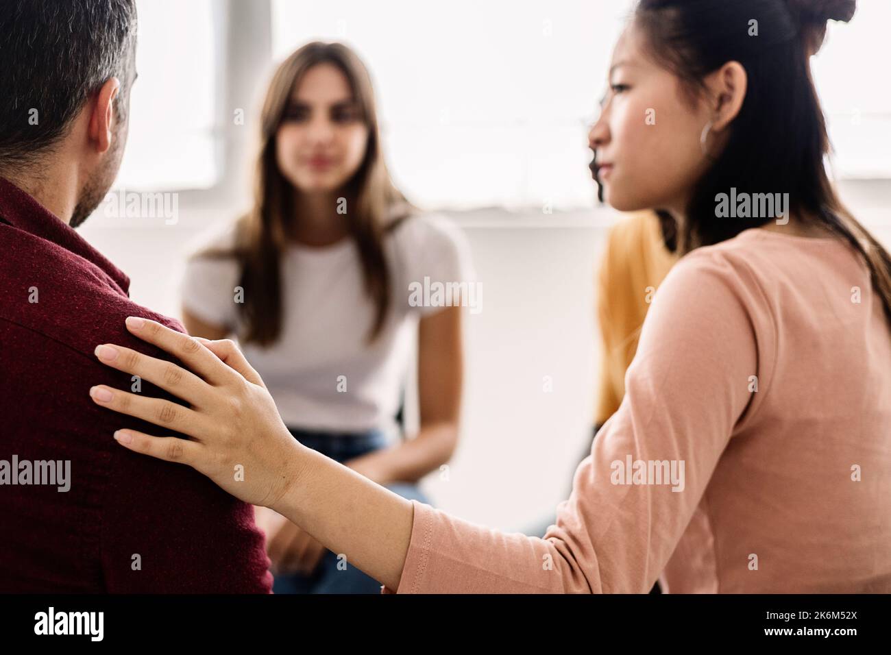 Diverse young teenage people receiving support during a therapy session ...