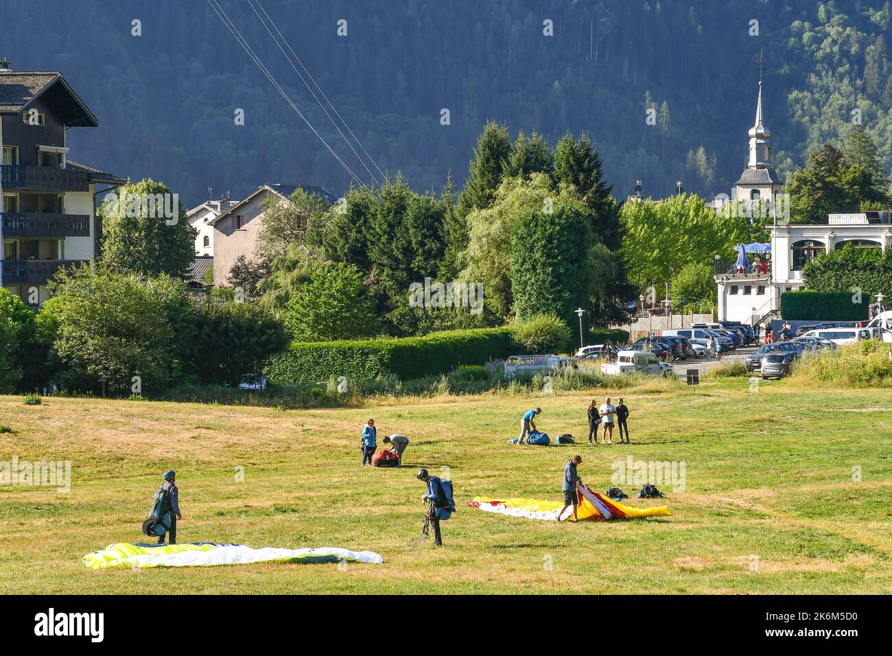 Paragliders on the landing point on a meadow near the centre of the ...