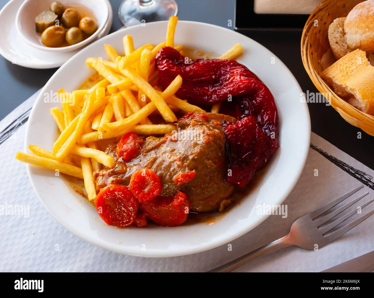 Dish of Spanish cuisine - pork cheeks with potatoes fri and stew ...