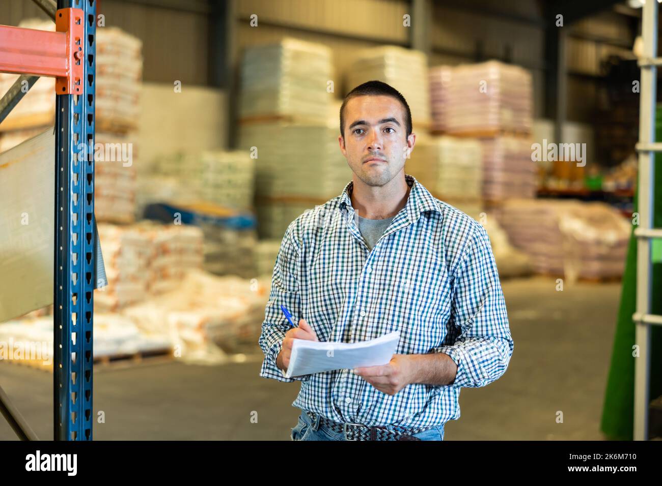 Engineer or foreman holding documents and checking inventory or job ...