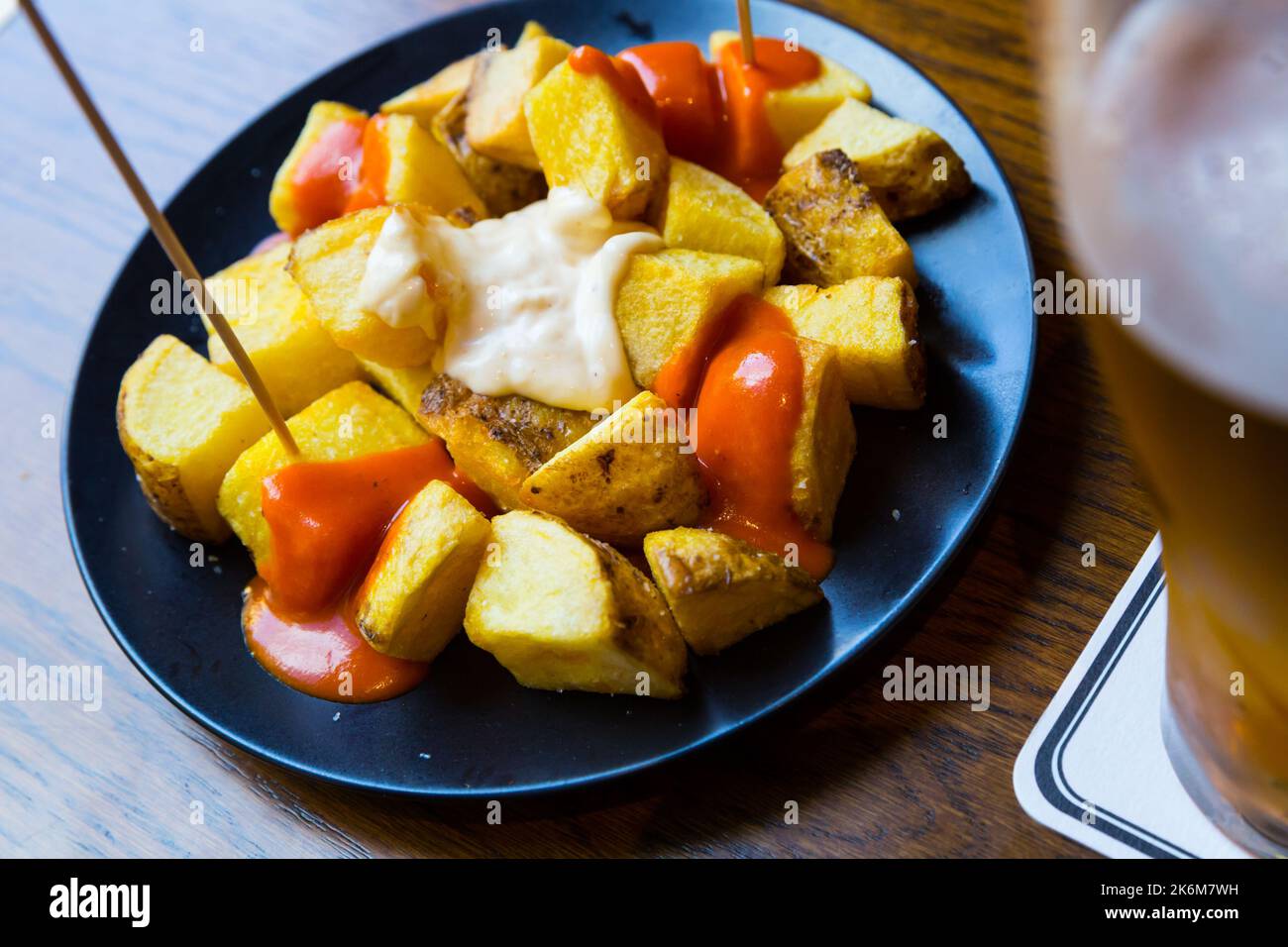 Traditional Spanish fried potatoes Patatas bravas served with cheese ...