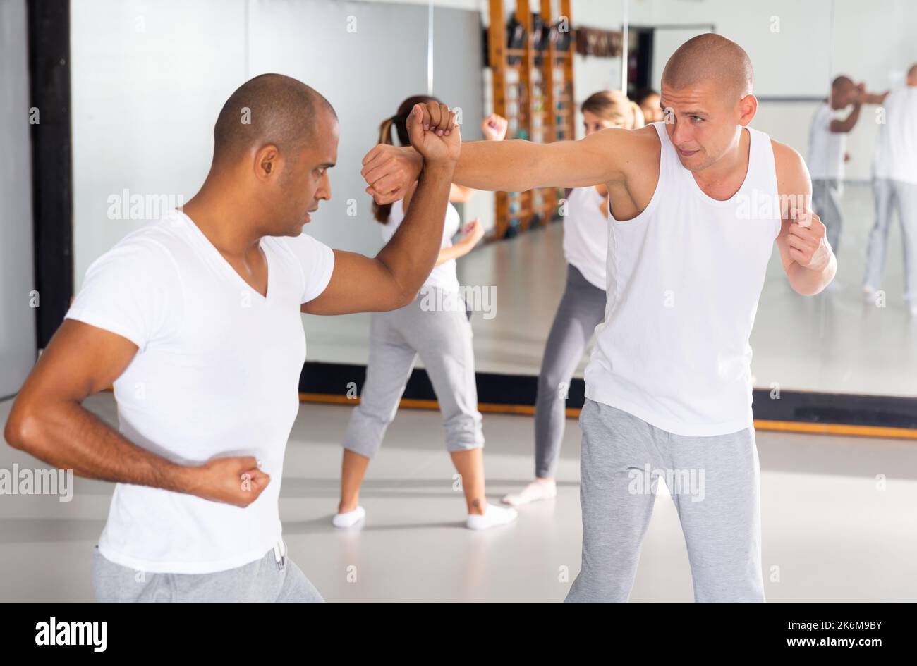 Men practicing basic moves during self defense course at gym Stock ...
