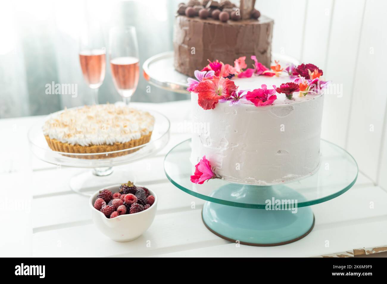 table served with cakes, pie, glasses with champagne and fruits ...